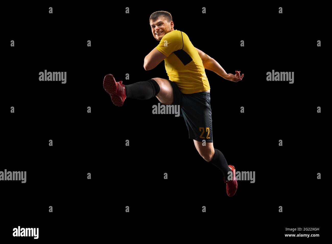 Powerful, flying above the field. Young football, soccer player in ...
