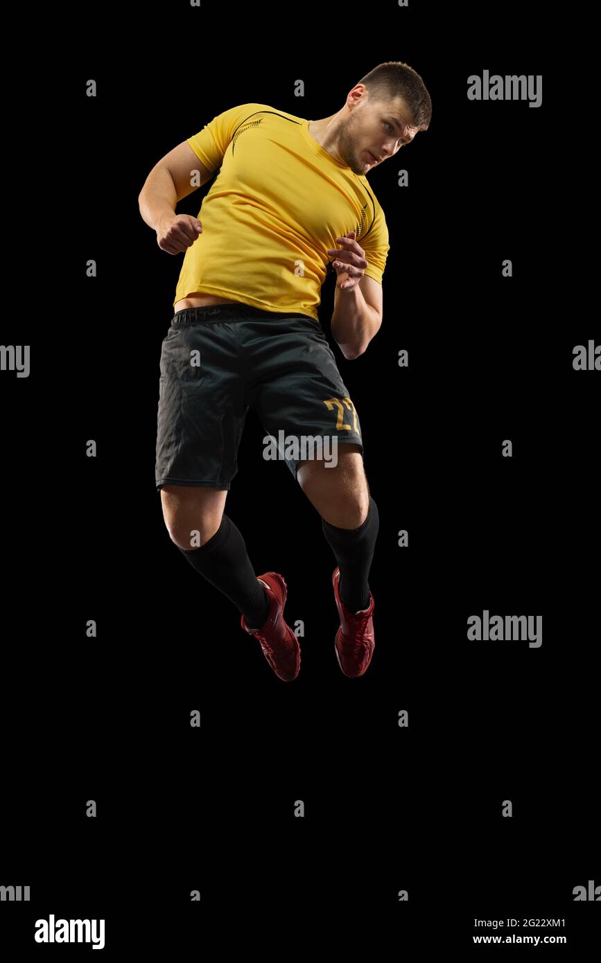 Powerful, flying above the field. Young football, soccer player in ...