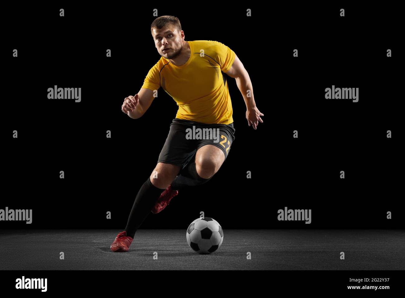 Powerful, flying above the field. Young football, soccer player in ...