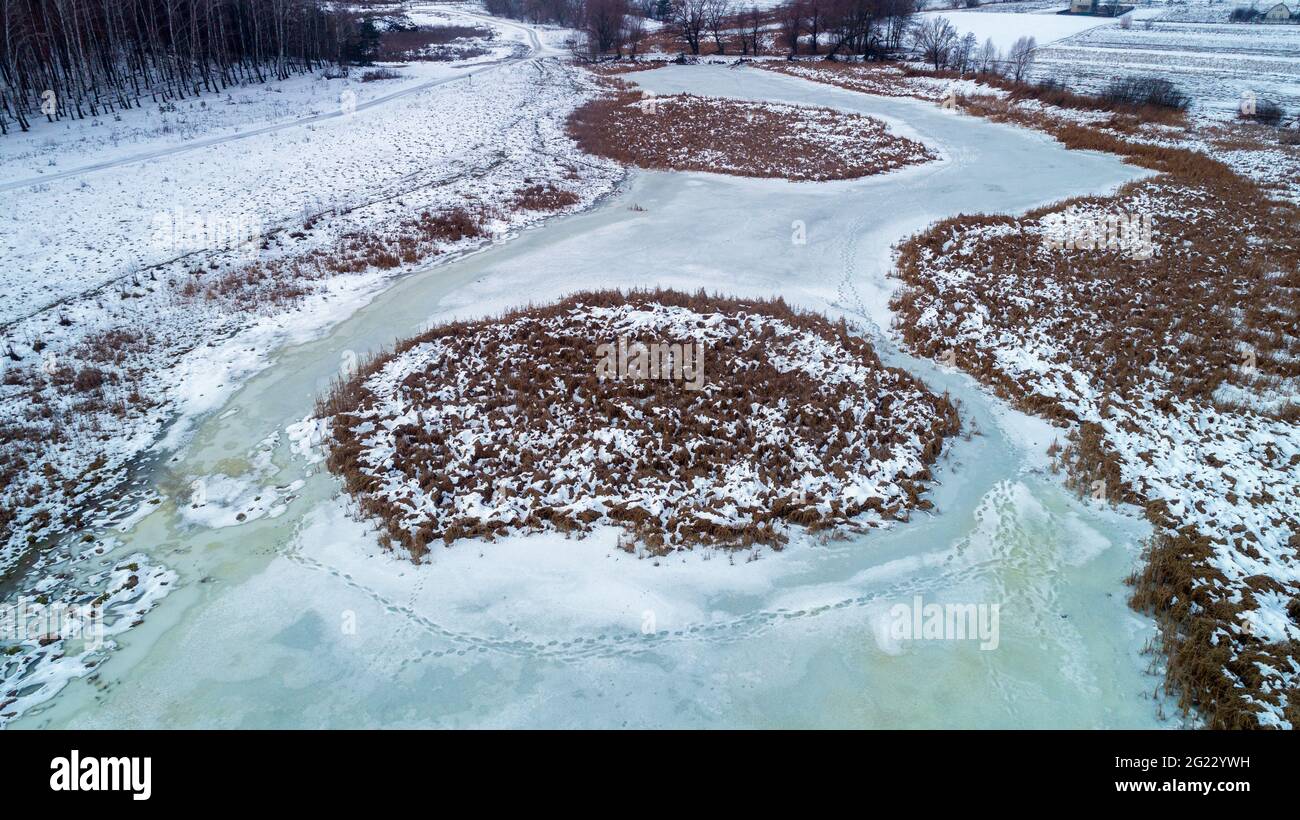 Aerial view of the frozen brook in winter. The texture of icy creek ...