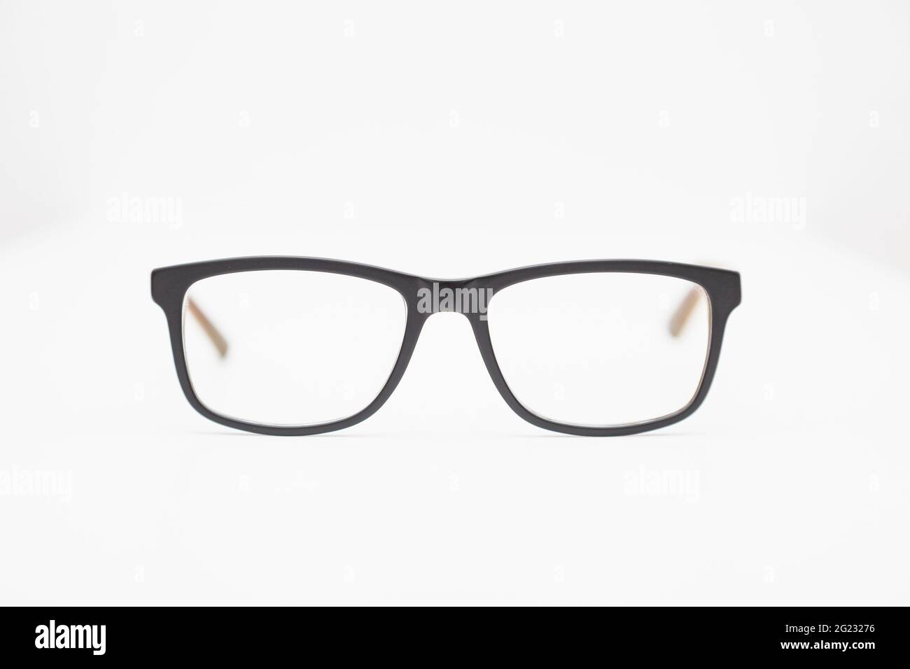 A pair of dark-rimmed glasses viewed from the front, with the temples ...