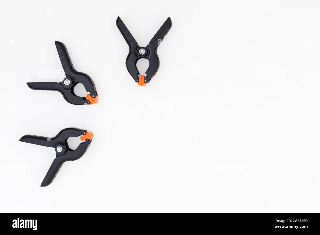 Three black clips placed in the upper left corner on a white background ...