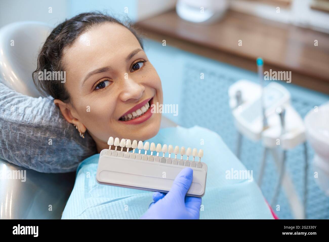 Brunette woman with beautiful smile before receiving dental care check ...