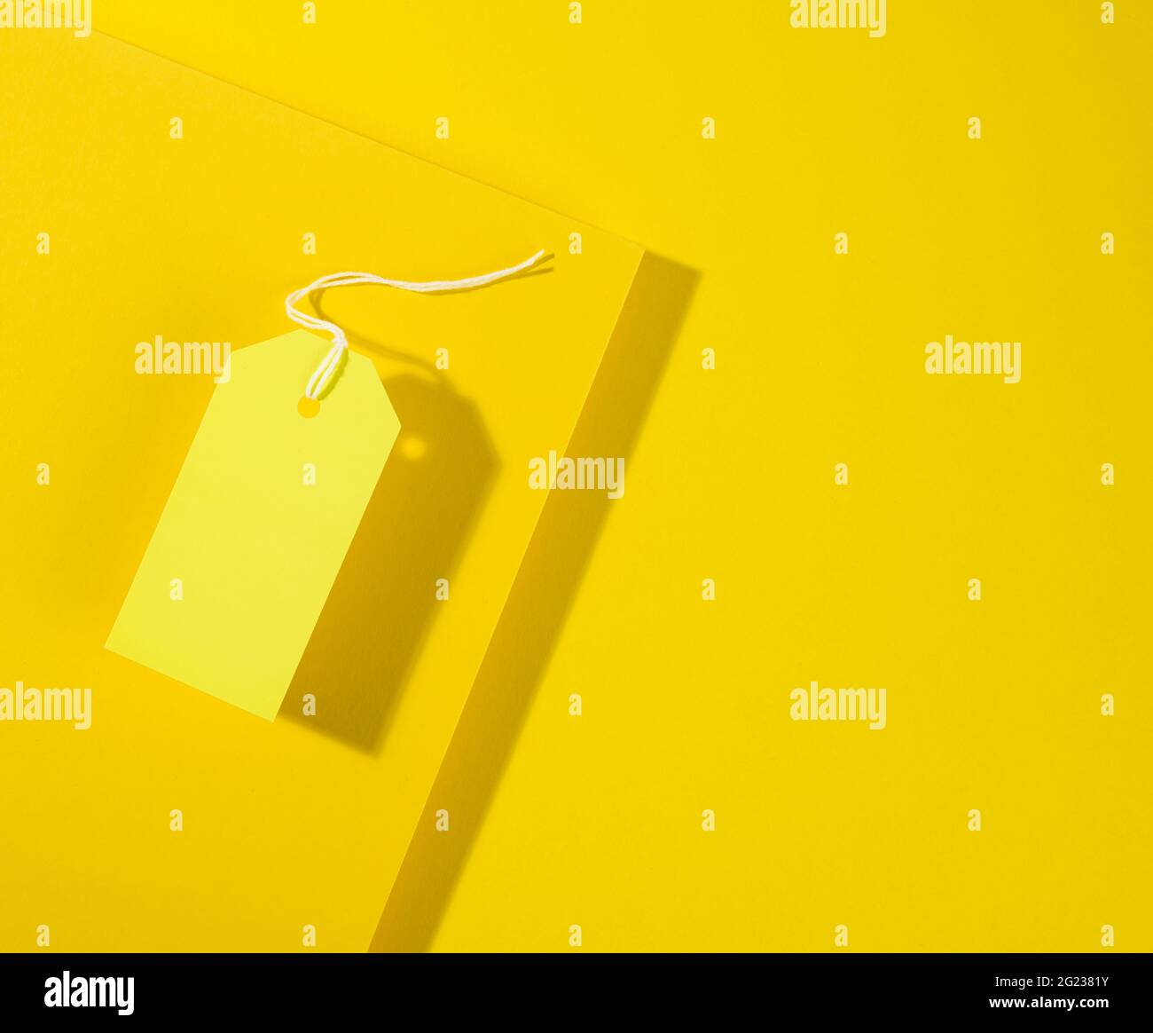 blank rectangular paper yellow price tag with white rope on yellow ...