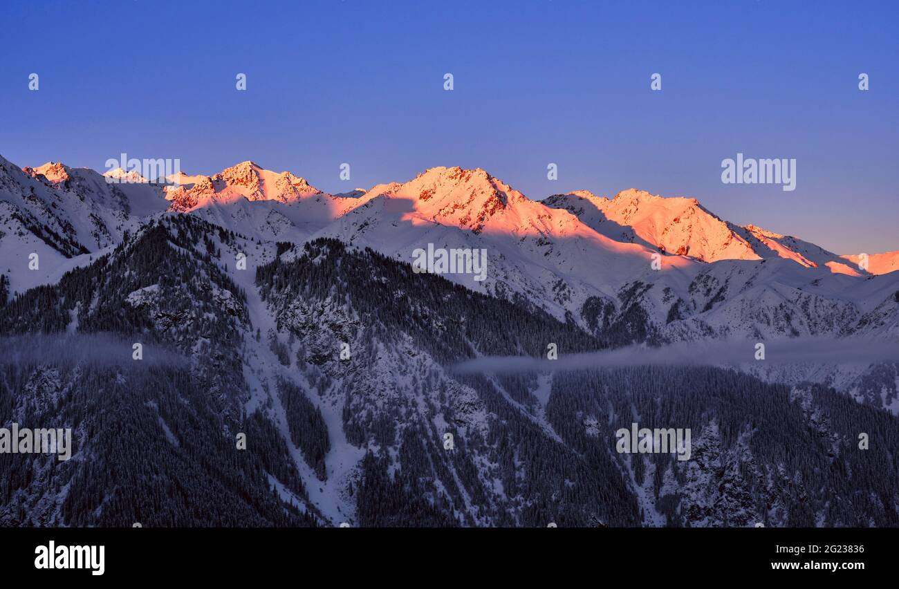 Soft morning sunlight on mountain ridges; rocky mountains covered with ...