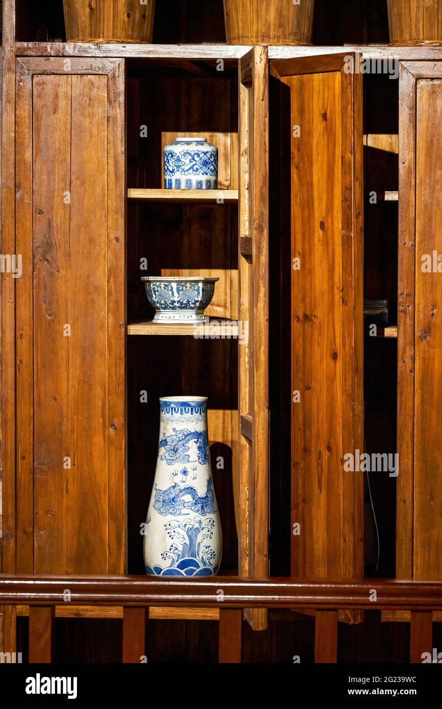 Carved mahogany cabinet and porcelain vase in Lingnan style, Guangdong ...