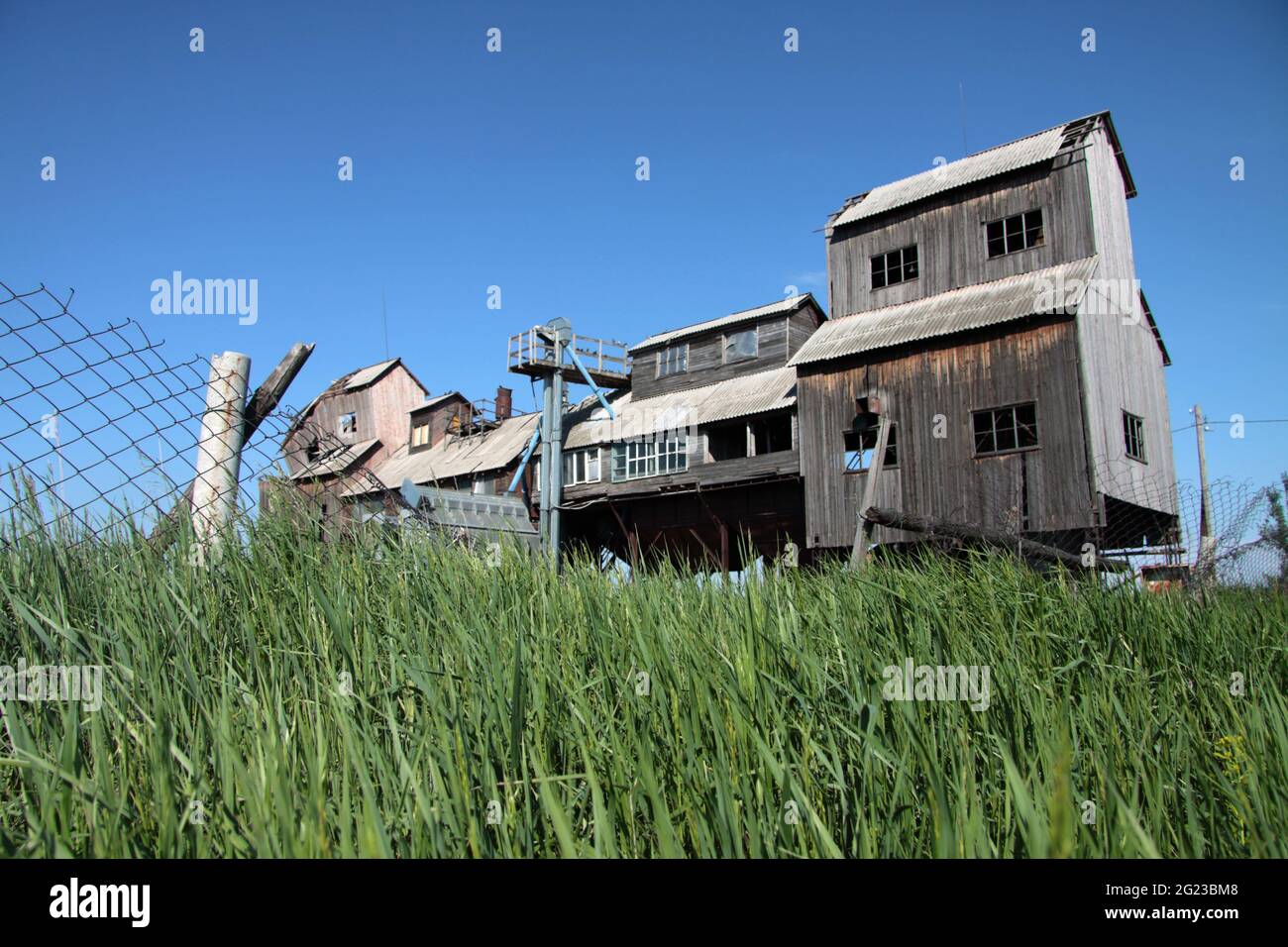 Abandoned farm view - partly ruined granary among green grass Stock ...