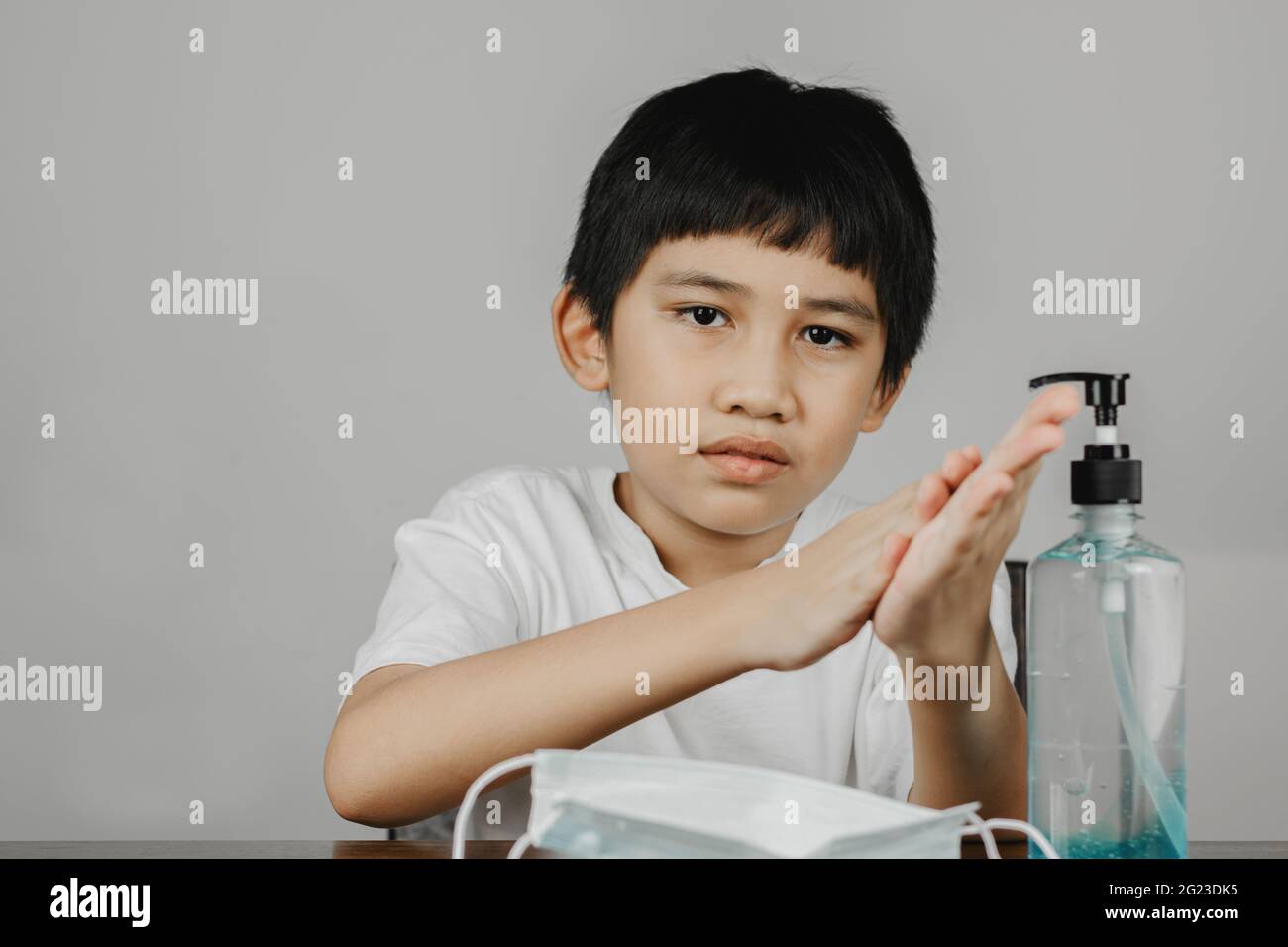Closeup a boy face cleaning his hands with alcohol gel Stock Photo - Alamy