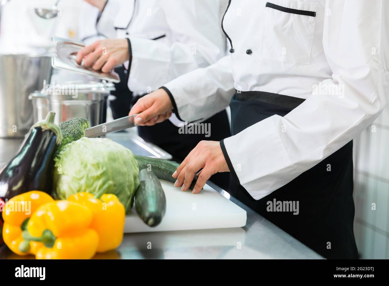 Team of chefs preparing food in canteen kitchen Stock Photo - Alamy