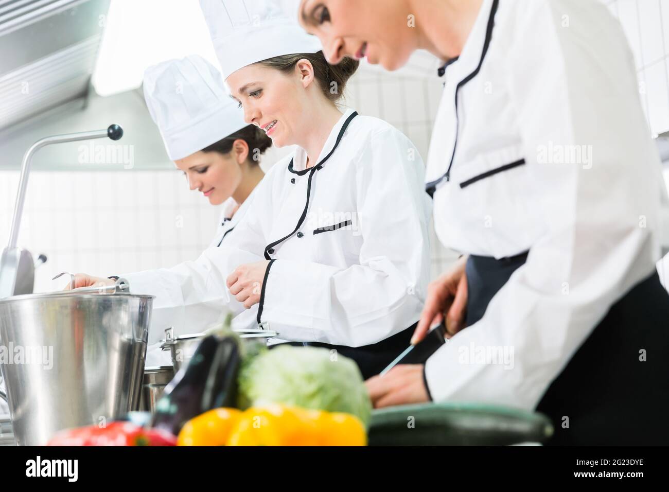 Team of chefs preparing food in canteen kitchen Stock Photo - Alamy