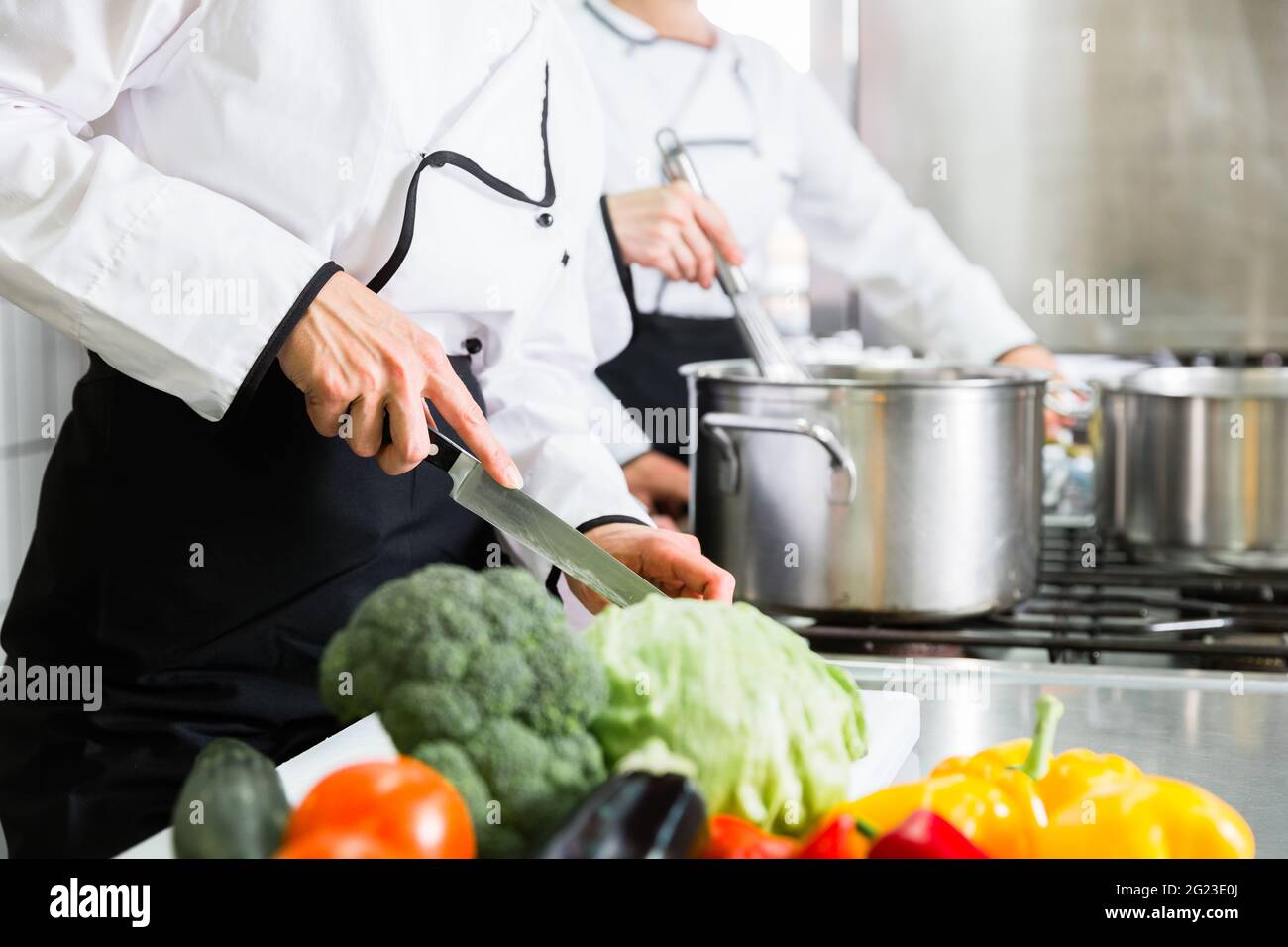 Team of chefs preparing food in canteen kitchen Stock Photo - Alamy