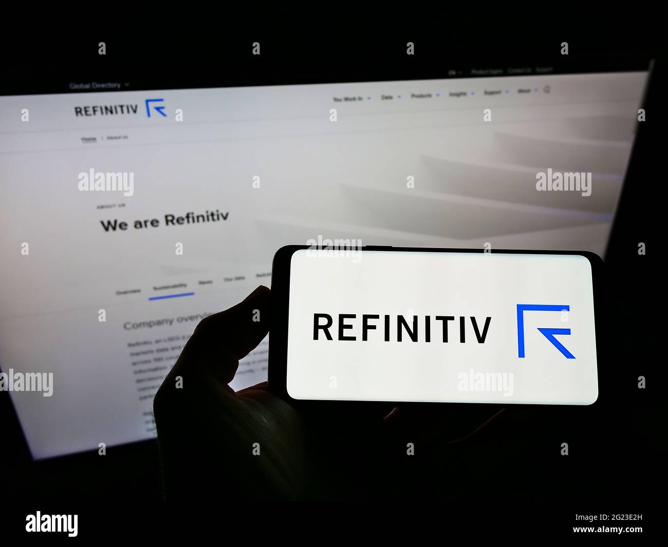 Person holding smartphone with logo of financial markets data comapny ...