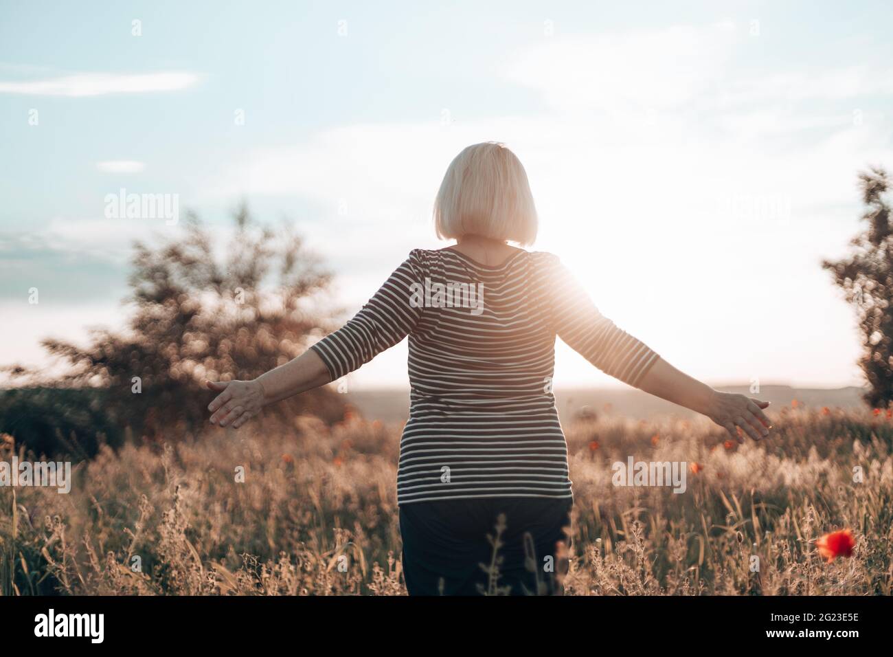 Hiking woman walking in blooming field at springtime Stock Photo - Alamy
