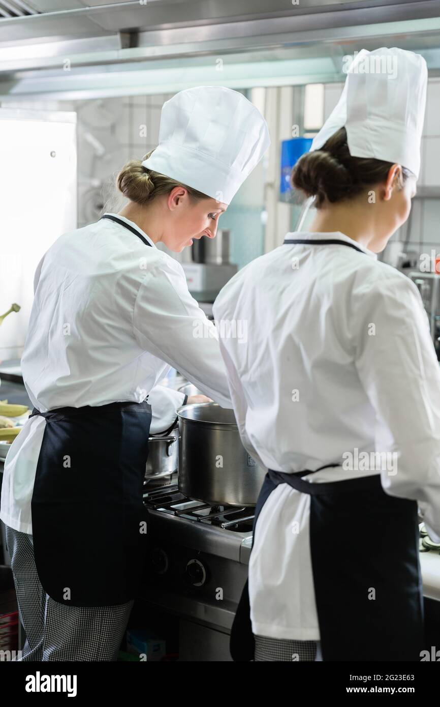 Team of female Chefs working in commercial catering kitchen Stock Photo ...