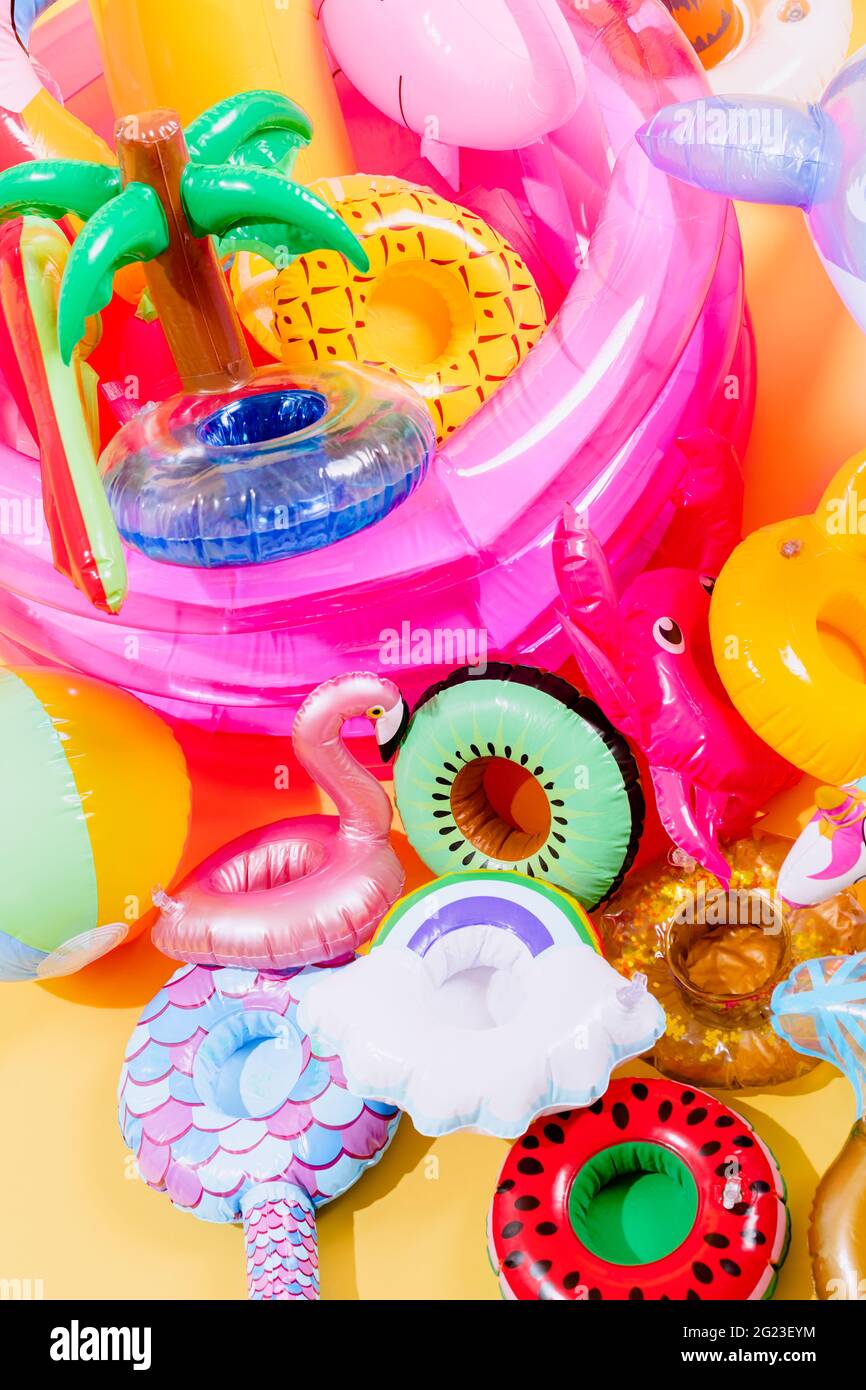 many pool inflatables of different shapes and colors on a yellow ...