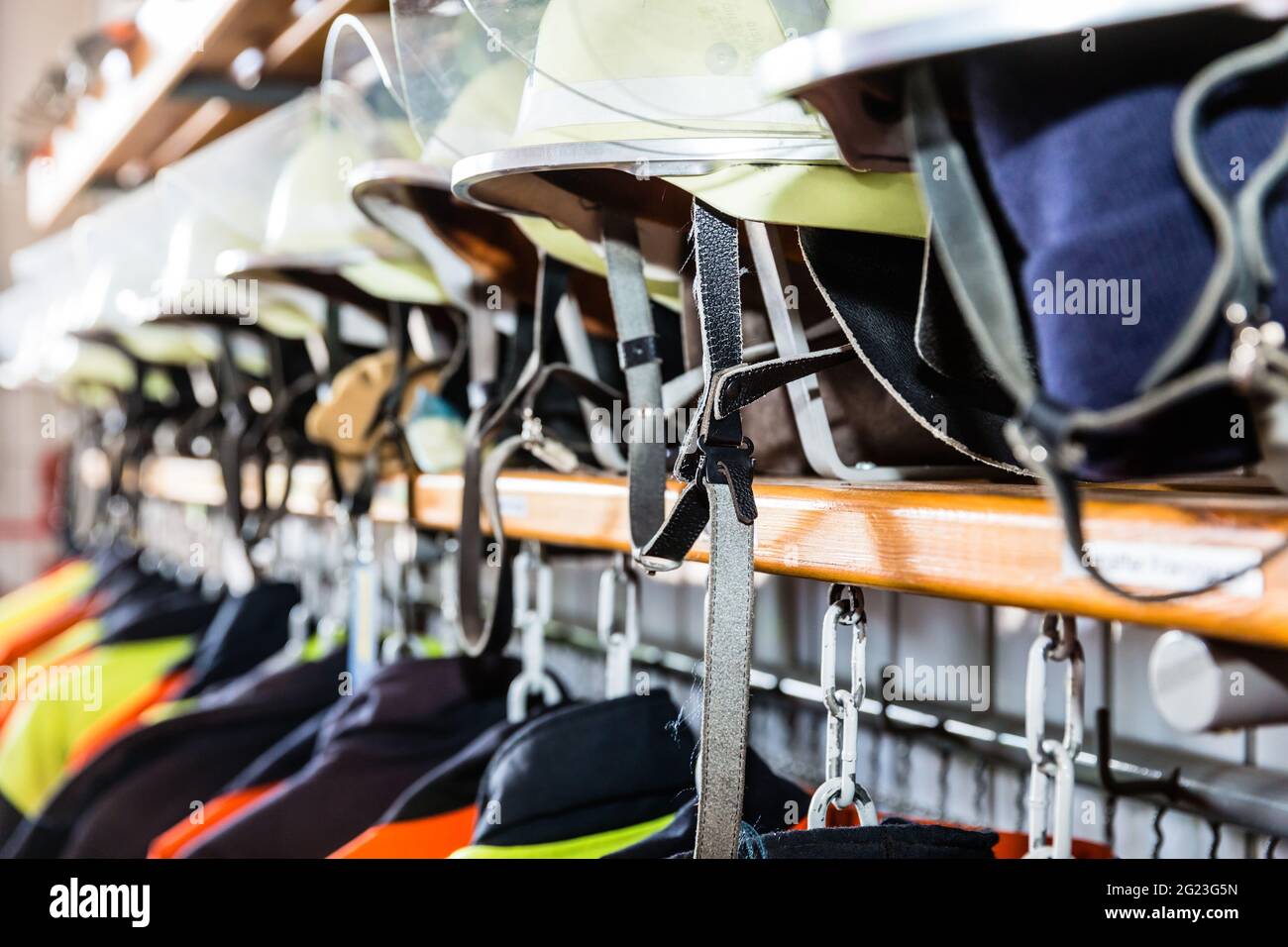 Helmets and uniforms in arsenal of fire brigade Stock Photo - Alamy