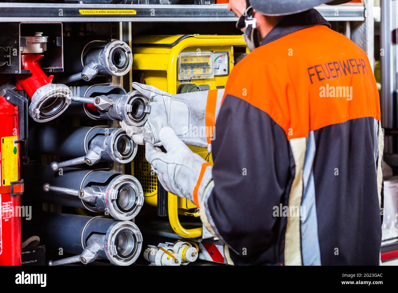 Fire fighter checking the hose laying vehicle Stock Photo - Alamy