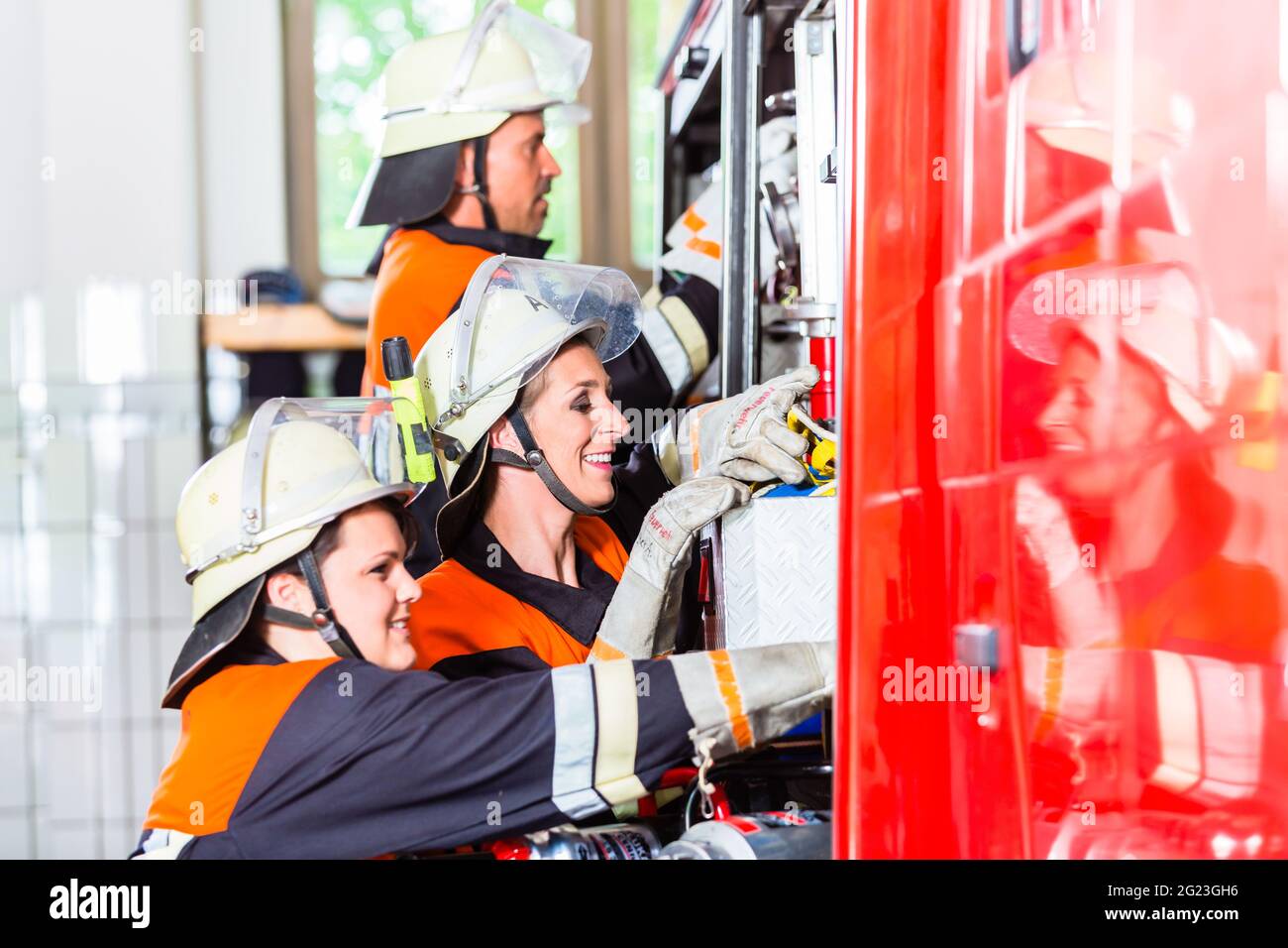Fire fighters attaching hose at hose laying vehicle Stock Photo - Alamy