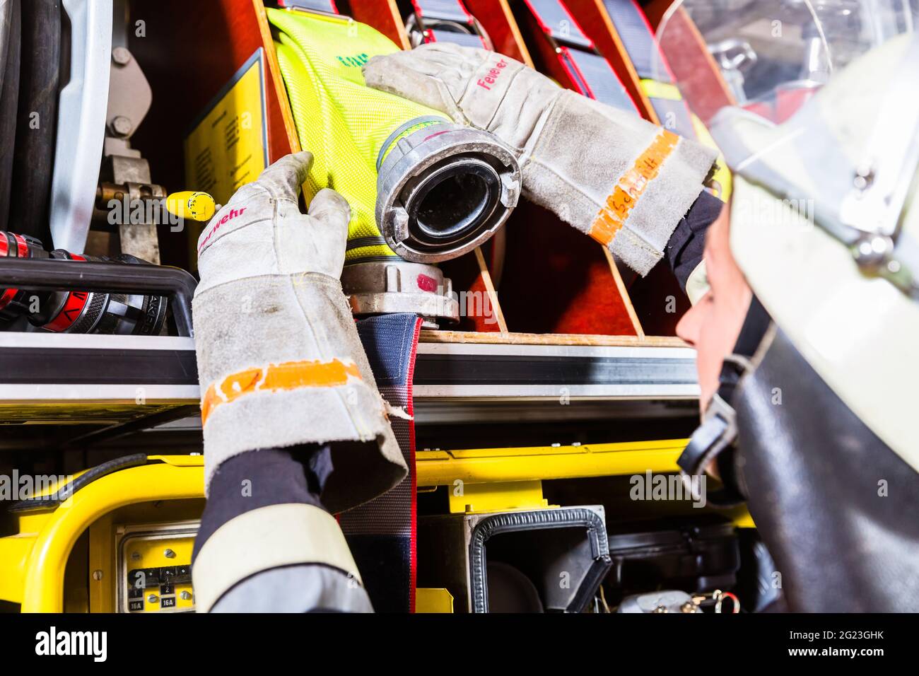 Fire fighter attaching hose at hose laying vehicle Stock Photo - Alamy