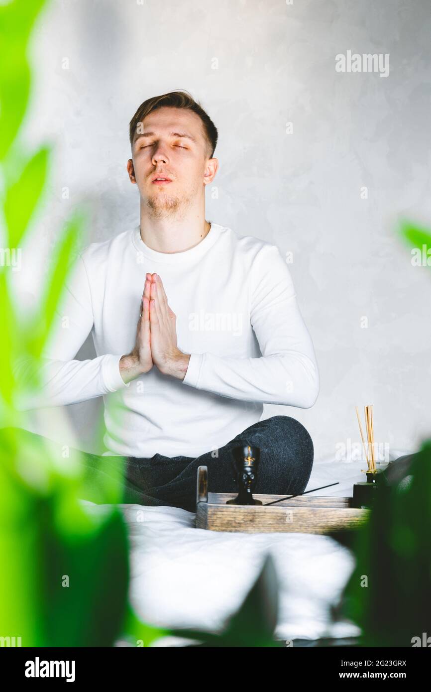 Man Sitting On Bed At Home Meditating after waking up in morning ...