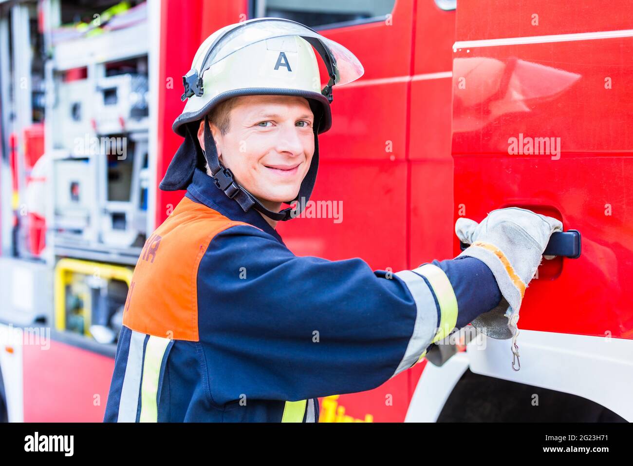 Man of the fire department getting on fire engine and smiling Stock ...