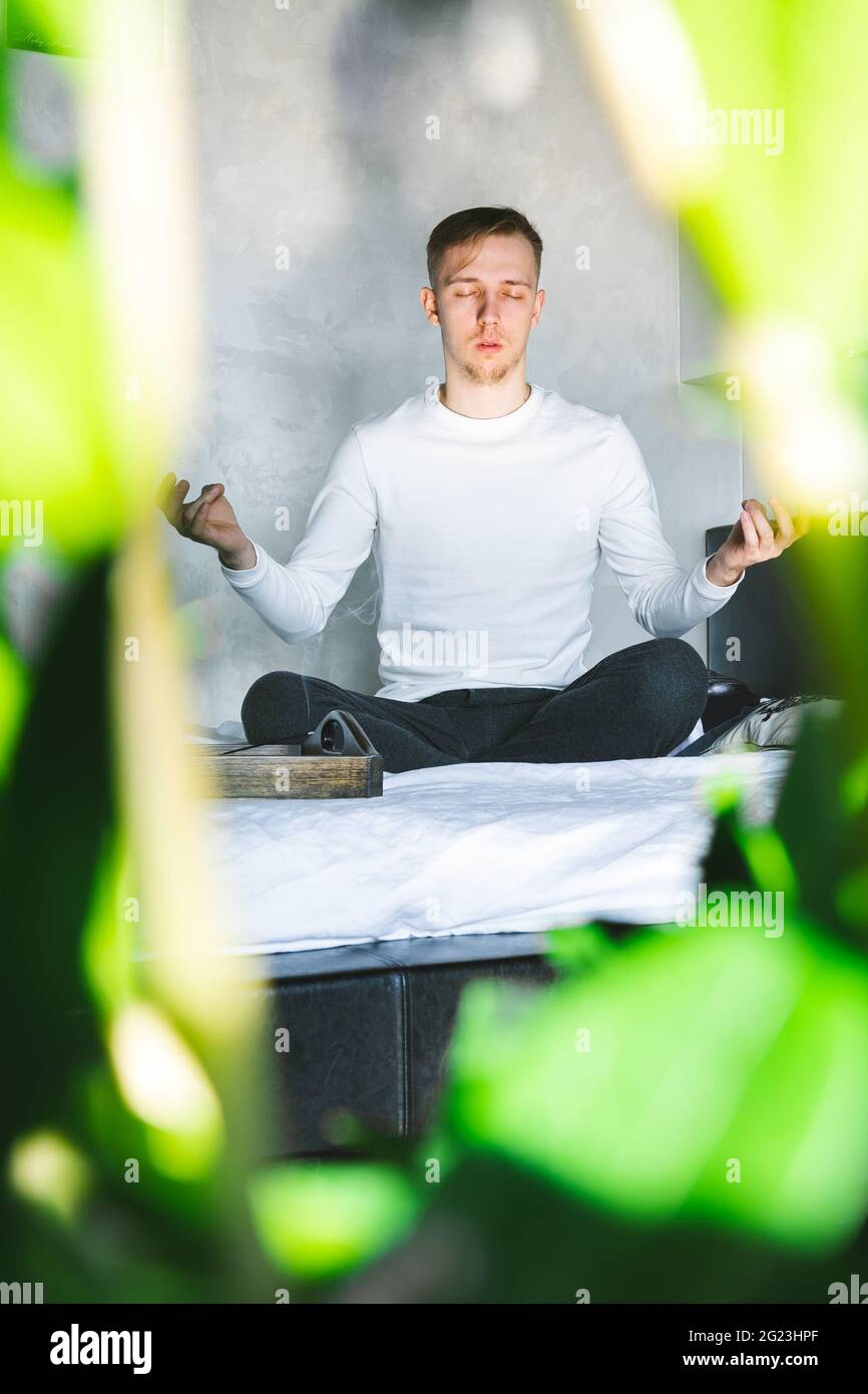 Man Sitting On Bed At Home Meditating after waking up in morning ...