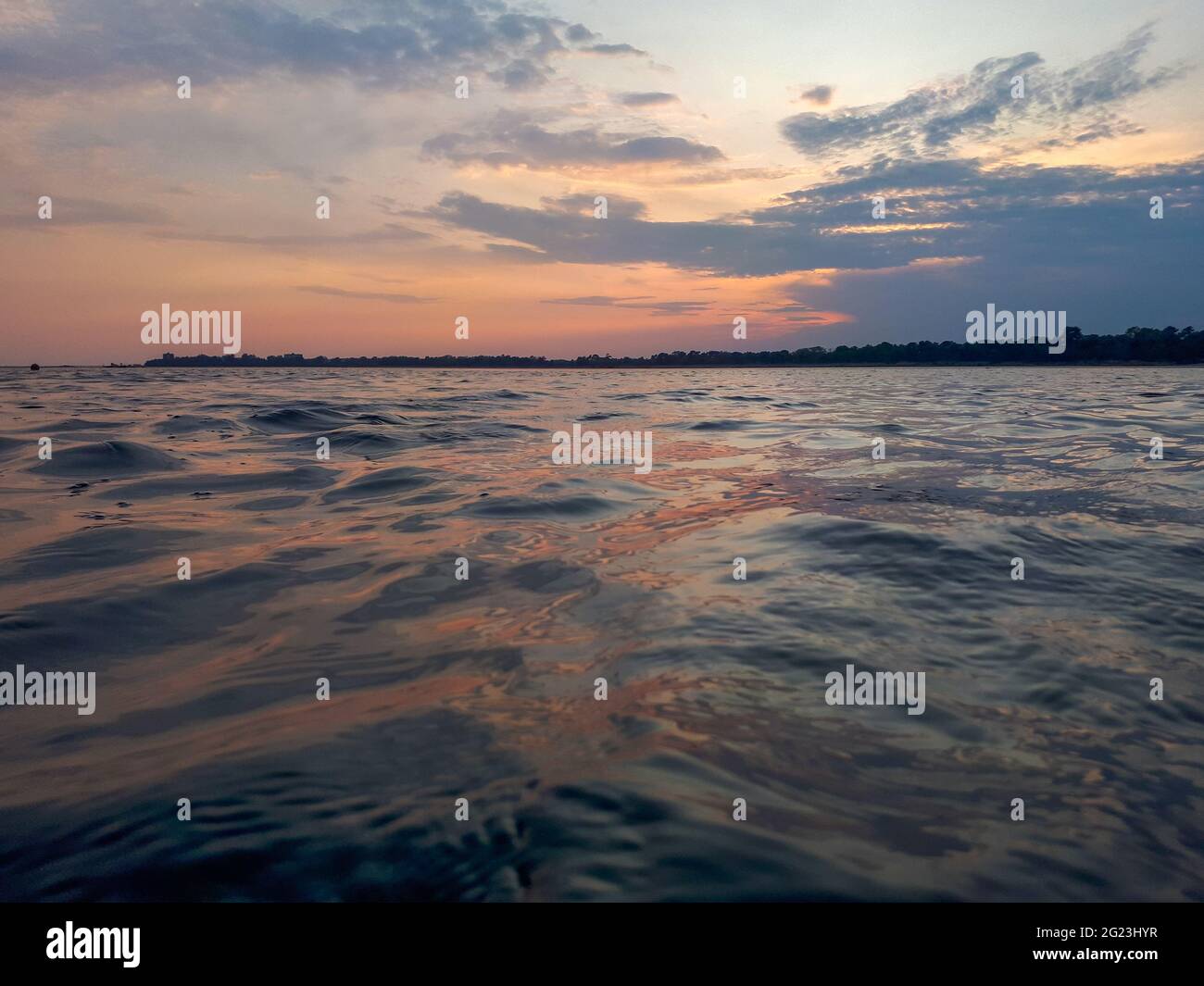 Surface level shot of sea water and sunset sky in summer in Grado ...