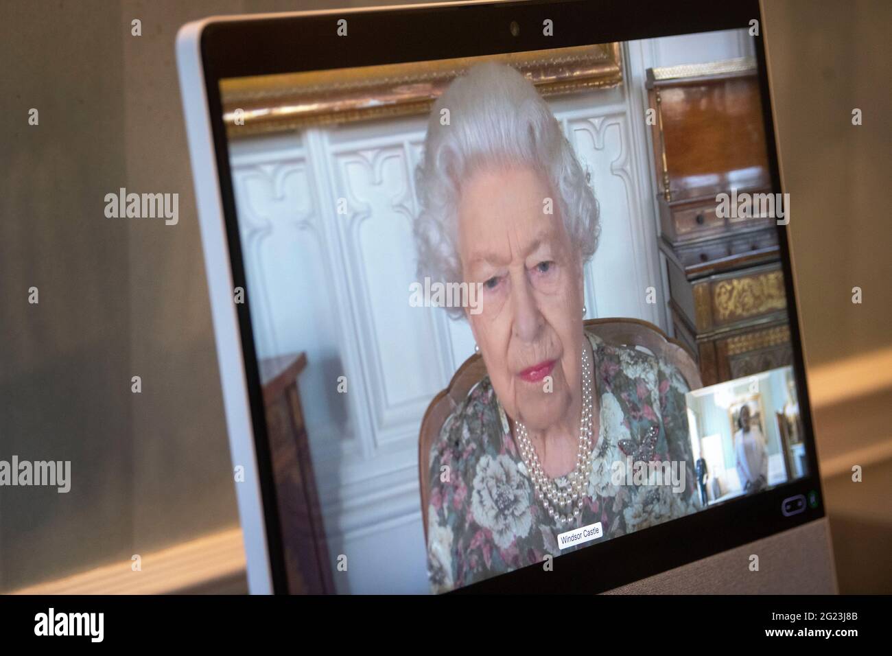 Queen Elizabeth II appears on a screen via videolink from Windsor ...