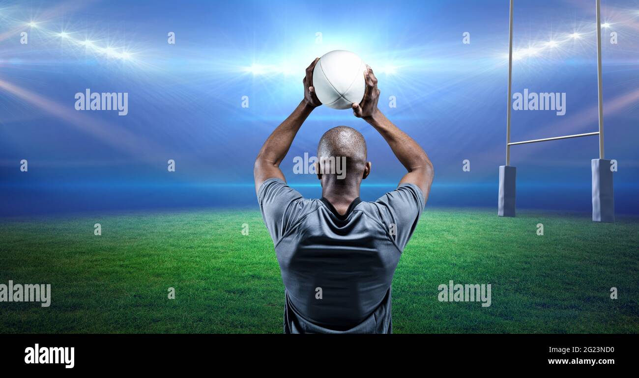 Rear view of african american male rugby player throwing a rugby ball ...