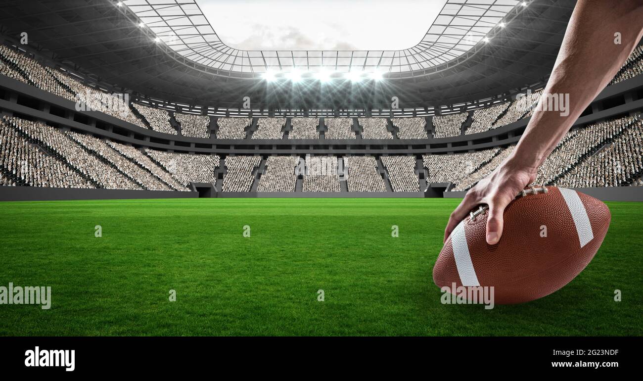 Close up of hands placing a rugby ball on grass field against stadium ...