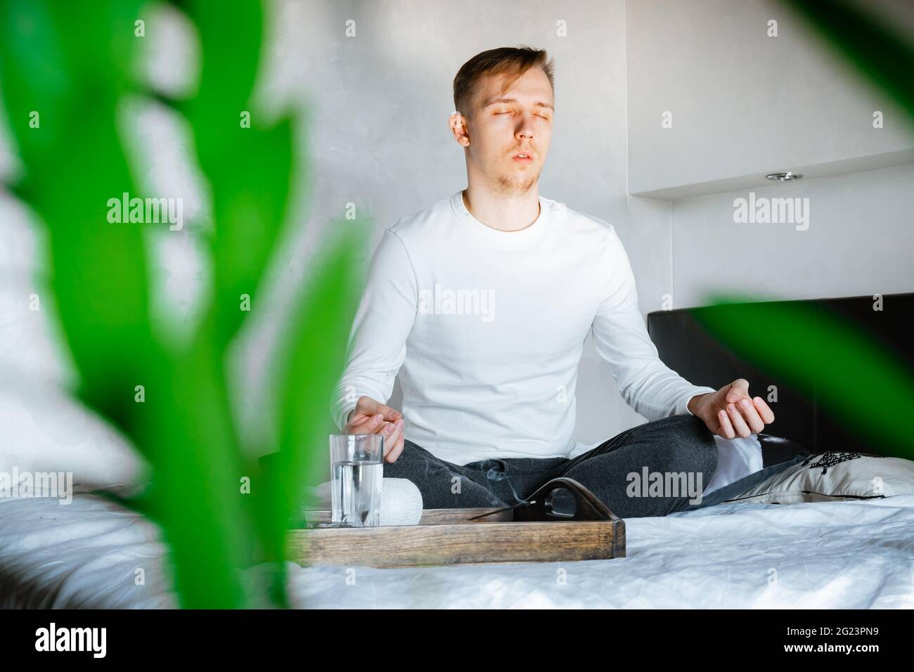 Man Sitting On Bed At Home Meditating after waking up in morning ...