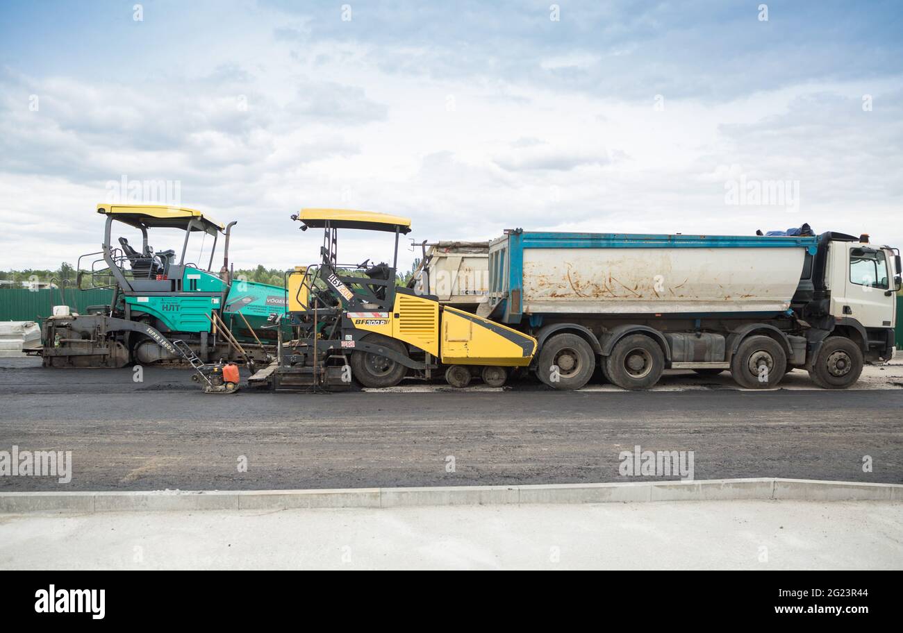 road machinery for laying asphalt pavement, asphalt pavers and a dump ...