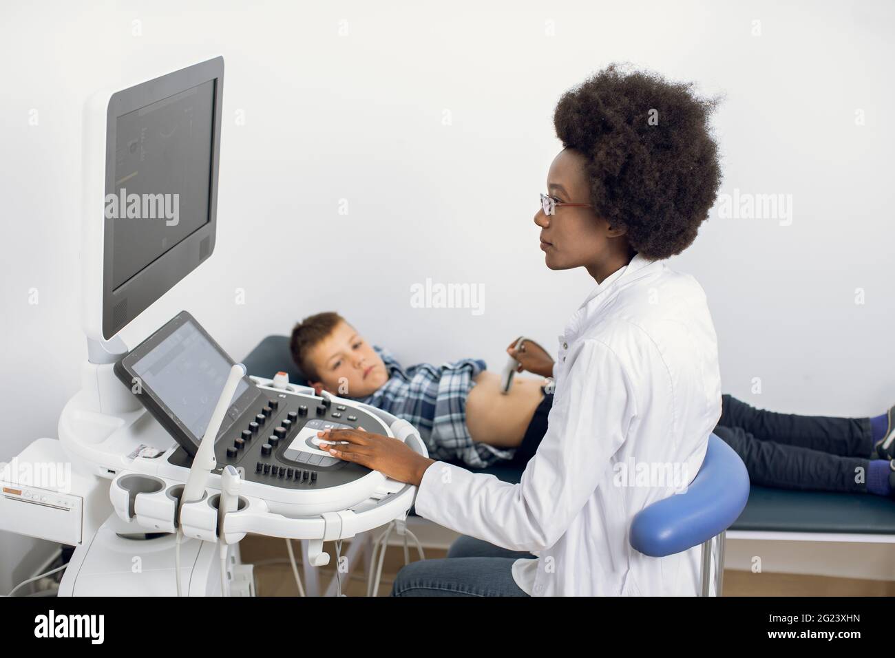 Ultrasound examination of the child in modern clinic. Young afro ...