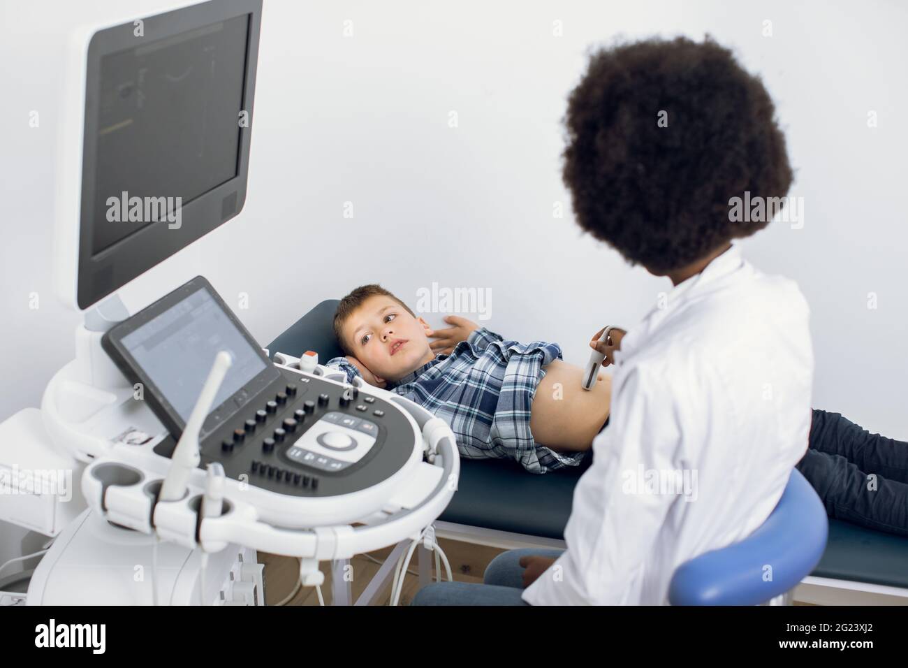 Ultrasound examination of the child in modern clinic. Young afro ...