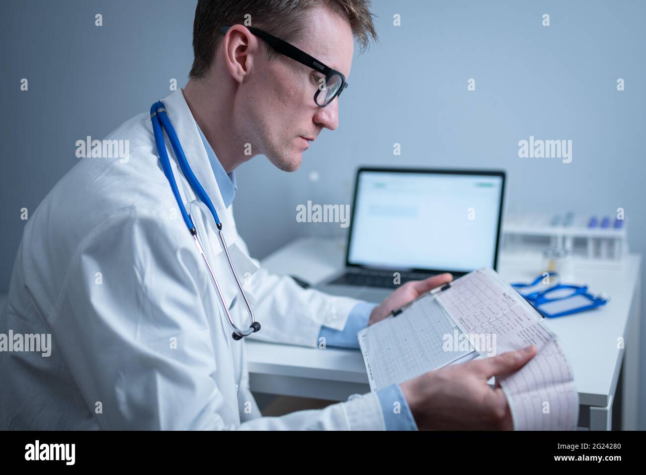 Cardiologist reading an ECG print-out. Doctor analyzing ...