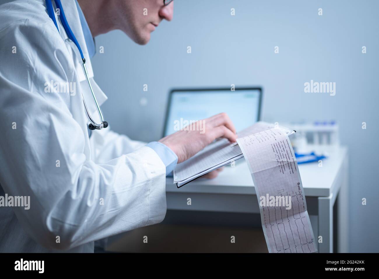 Cardiologist reading an ECG print-out. Doctor analyzing ...
