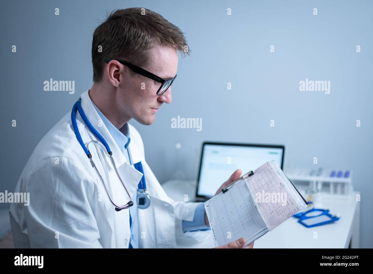 Cardiologist reading an ECG print-out. Doctor analyzing ...