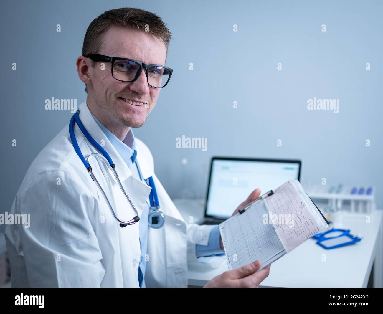 Cardiologist reading an ECG print-out. Doctor analyzing ...