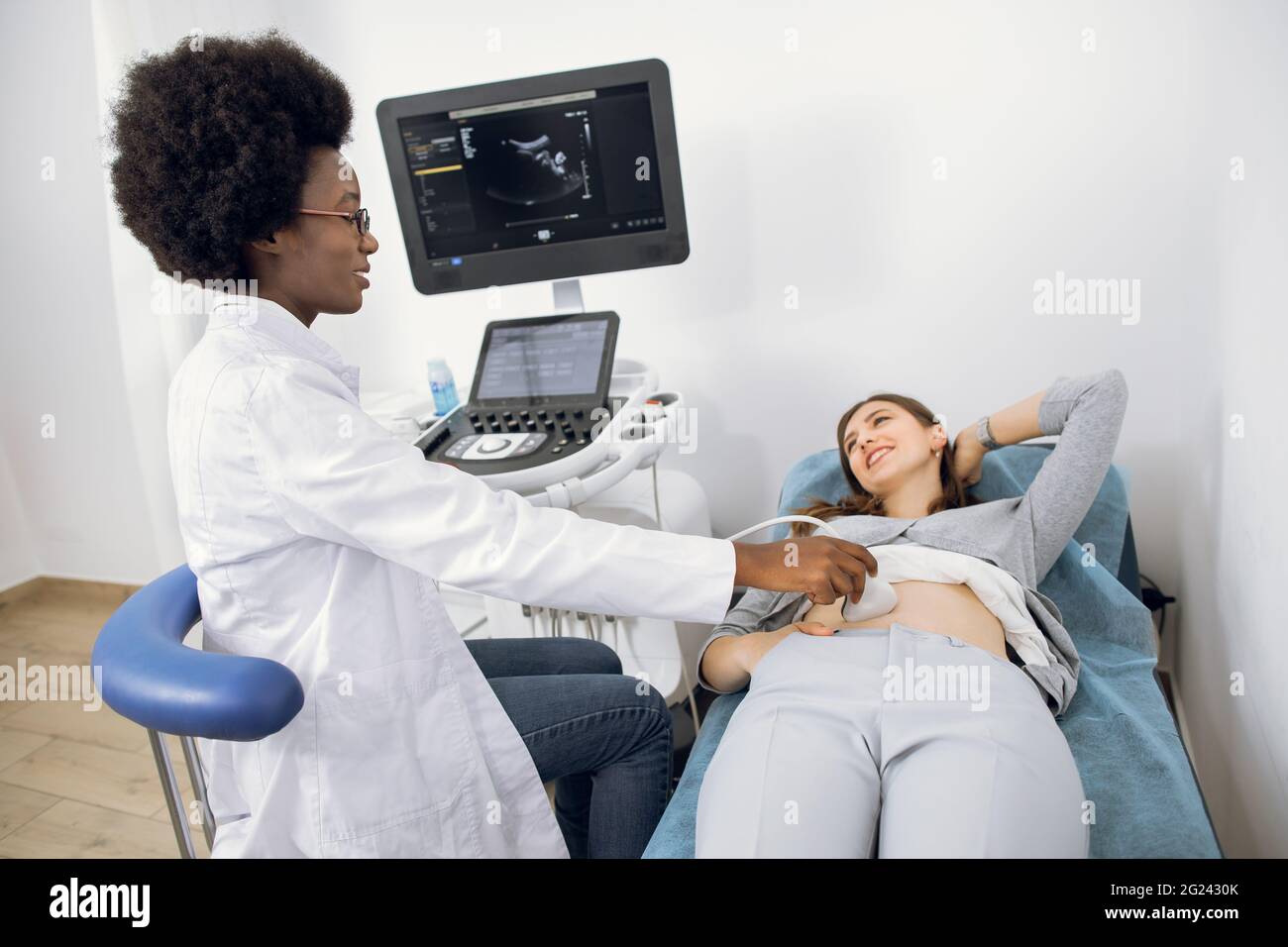Young African female doctor using ultrasound machine in clinic, makes ...