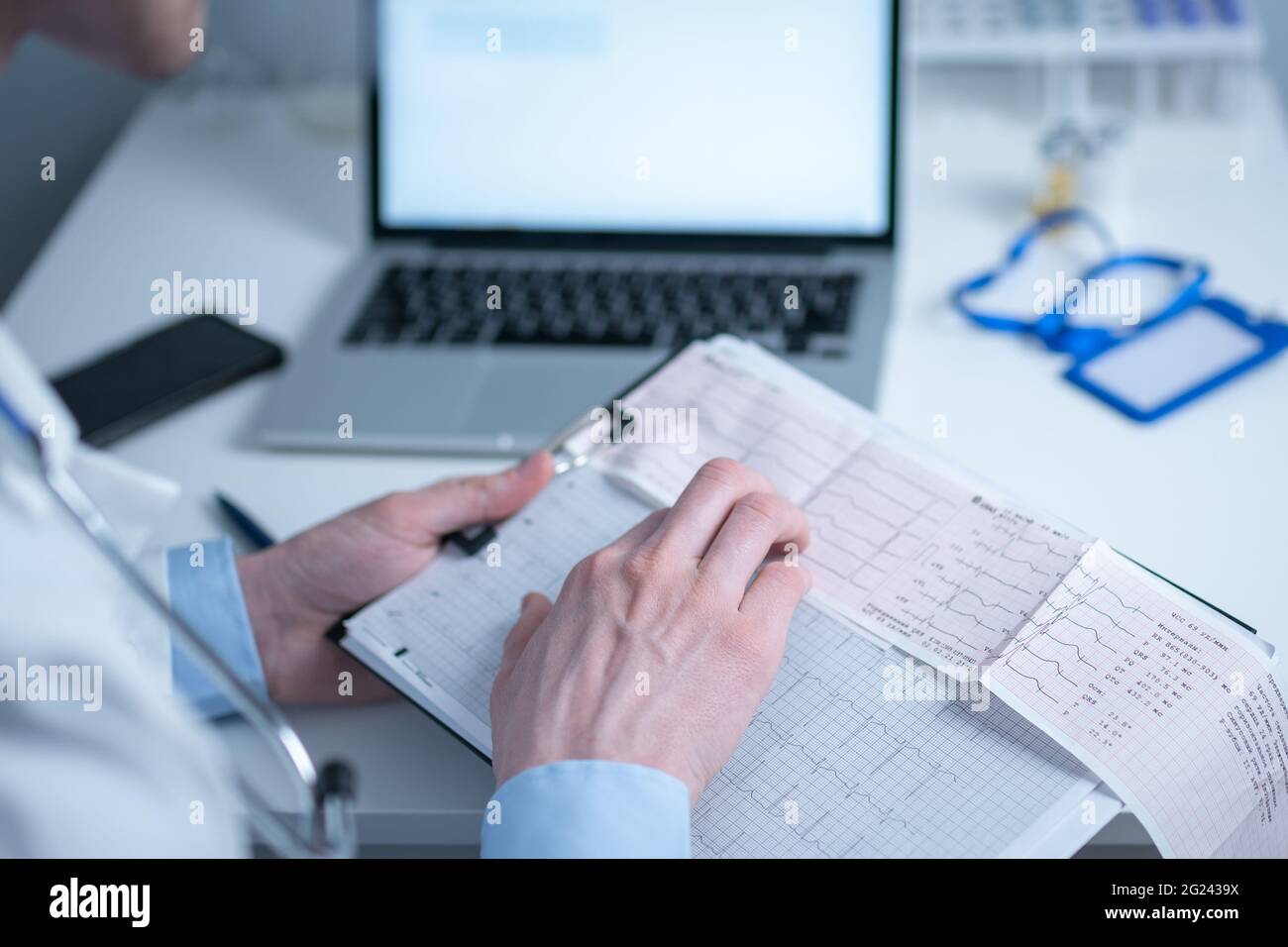 Cardiologist reading an ECG print-out. Doctor analyzing ...