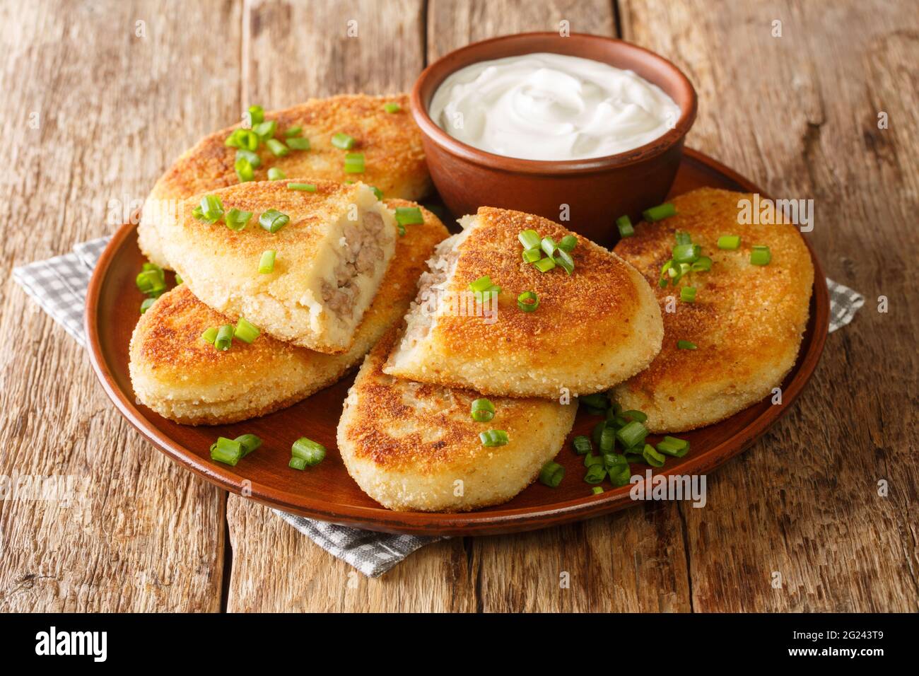 Ukrainian food potato zrazy with meat with sour cream close-up in a ...