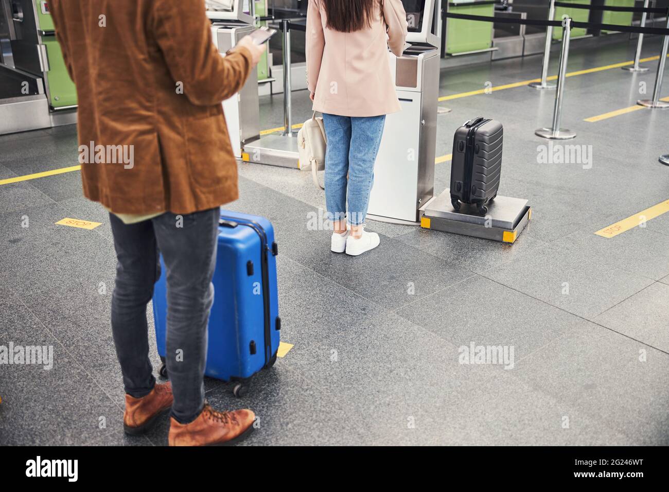 Passengers using baggage check weighing machine at airport Stock Photo ...
