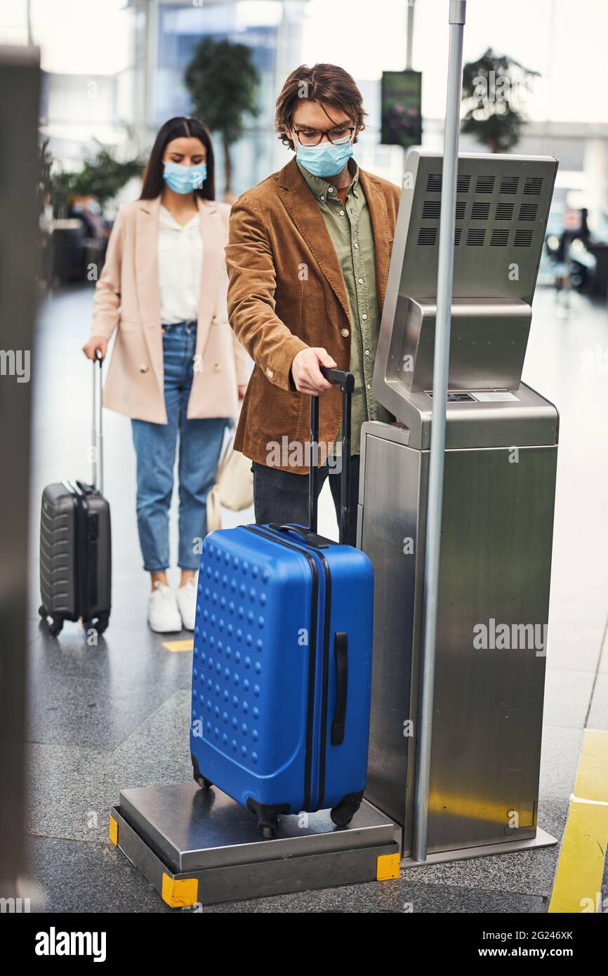 Weighing luggage at an airport hi-res stock photography and images - Alamy