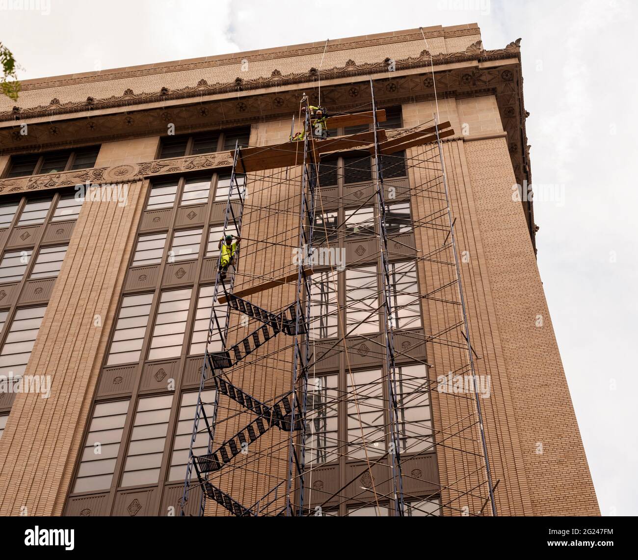 Workers on a scaffold on the exterior of the Morgan Processing and ...