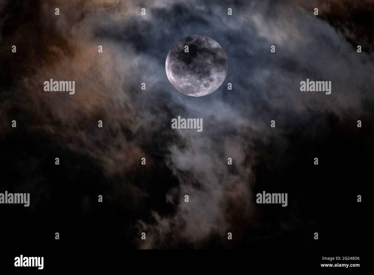 Full Moon behind clouds Stock Photo - Alamy