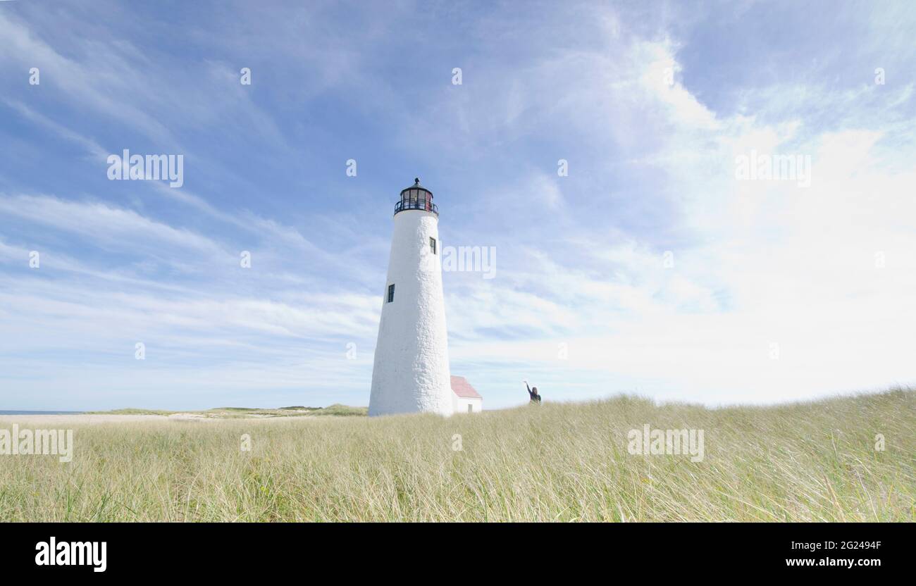USA, Massachusetts, Nantucket Island, Woman waving by Great Point Light ...