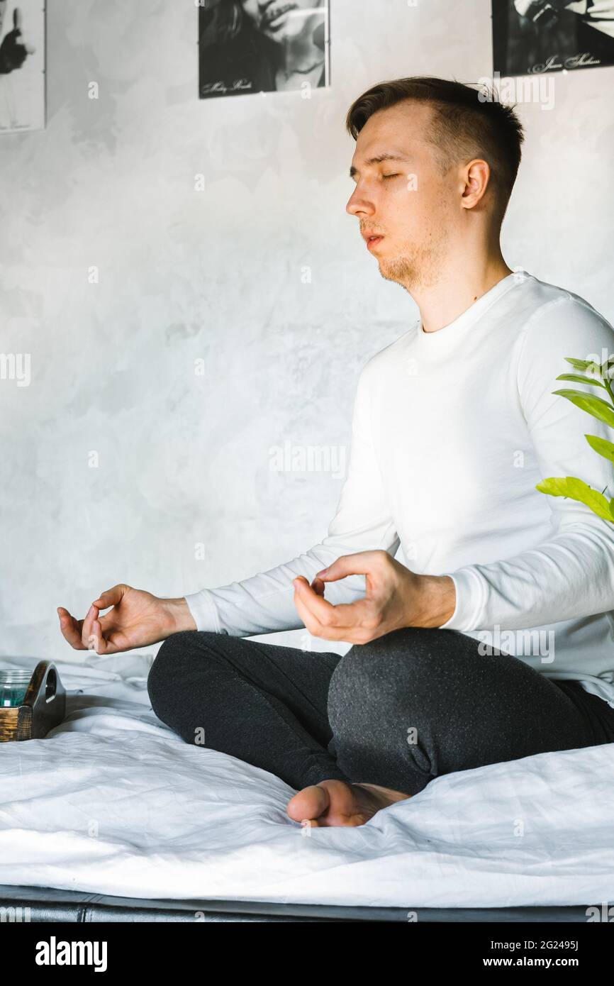 Man Sitting On Bed At Home Meditating after waking up in morning ...