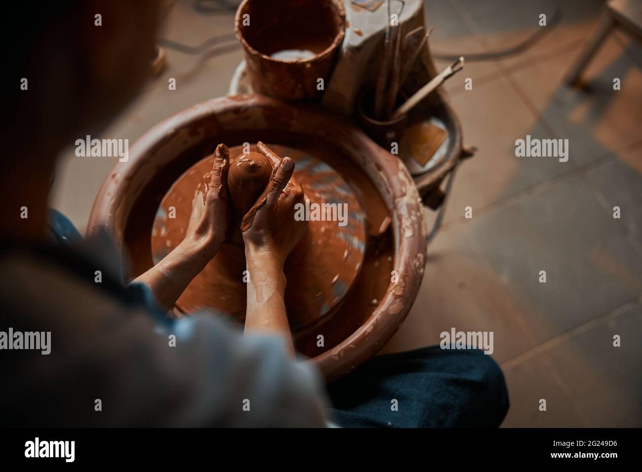 Professional ceramicist working with fresh wet clay in pottery workshop ...