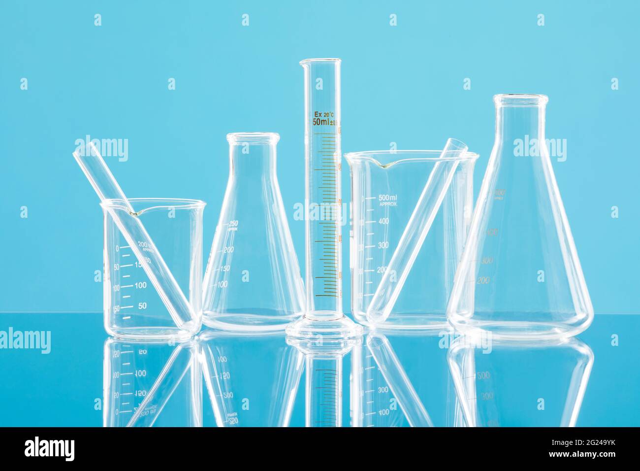 Laboratory glassware against blue background Stock Photo - Alamy