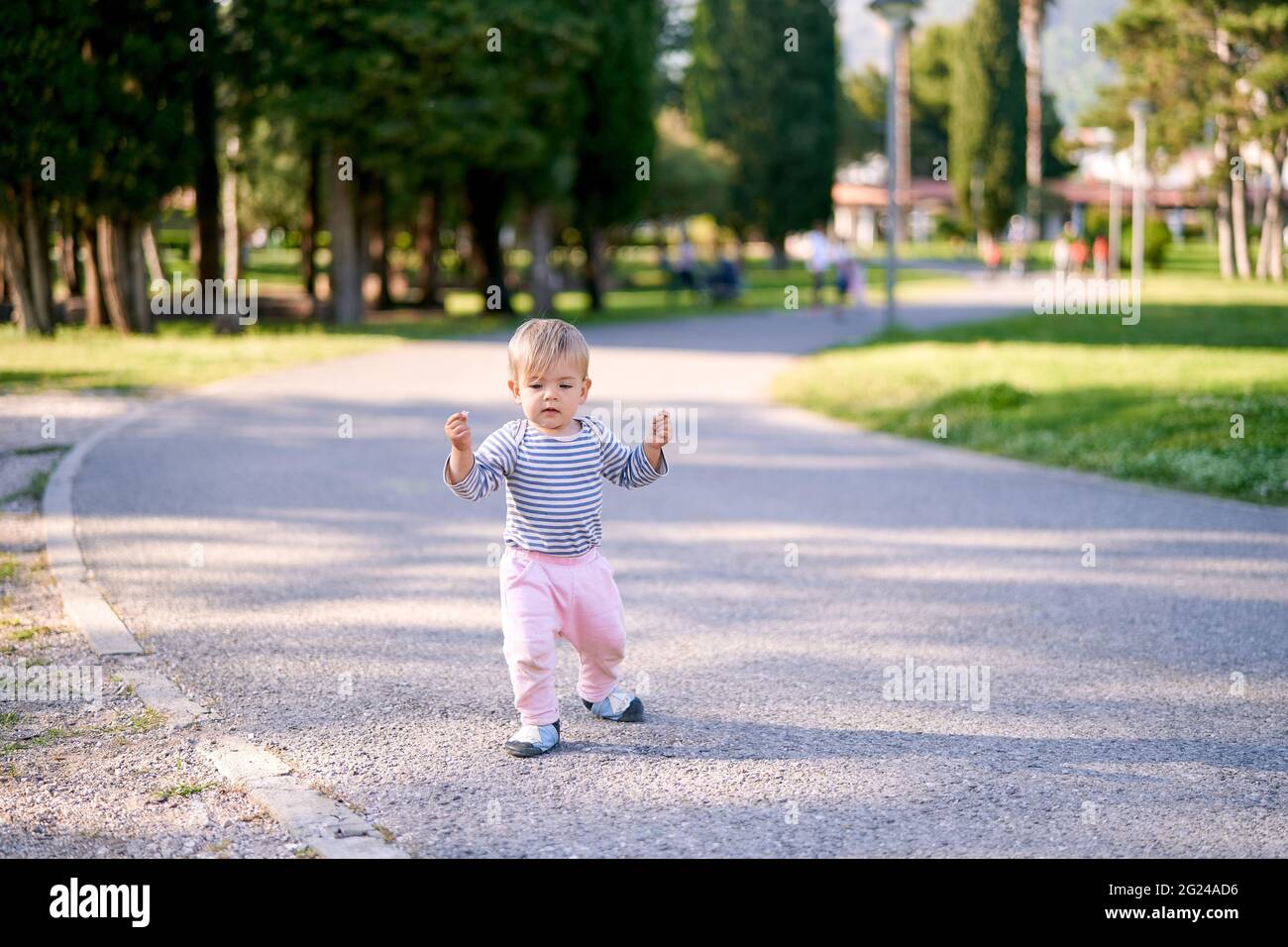 Little child walking along the path in the green park Stock Photo - Alamy